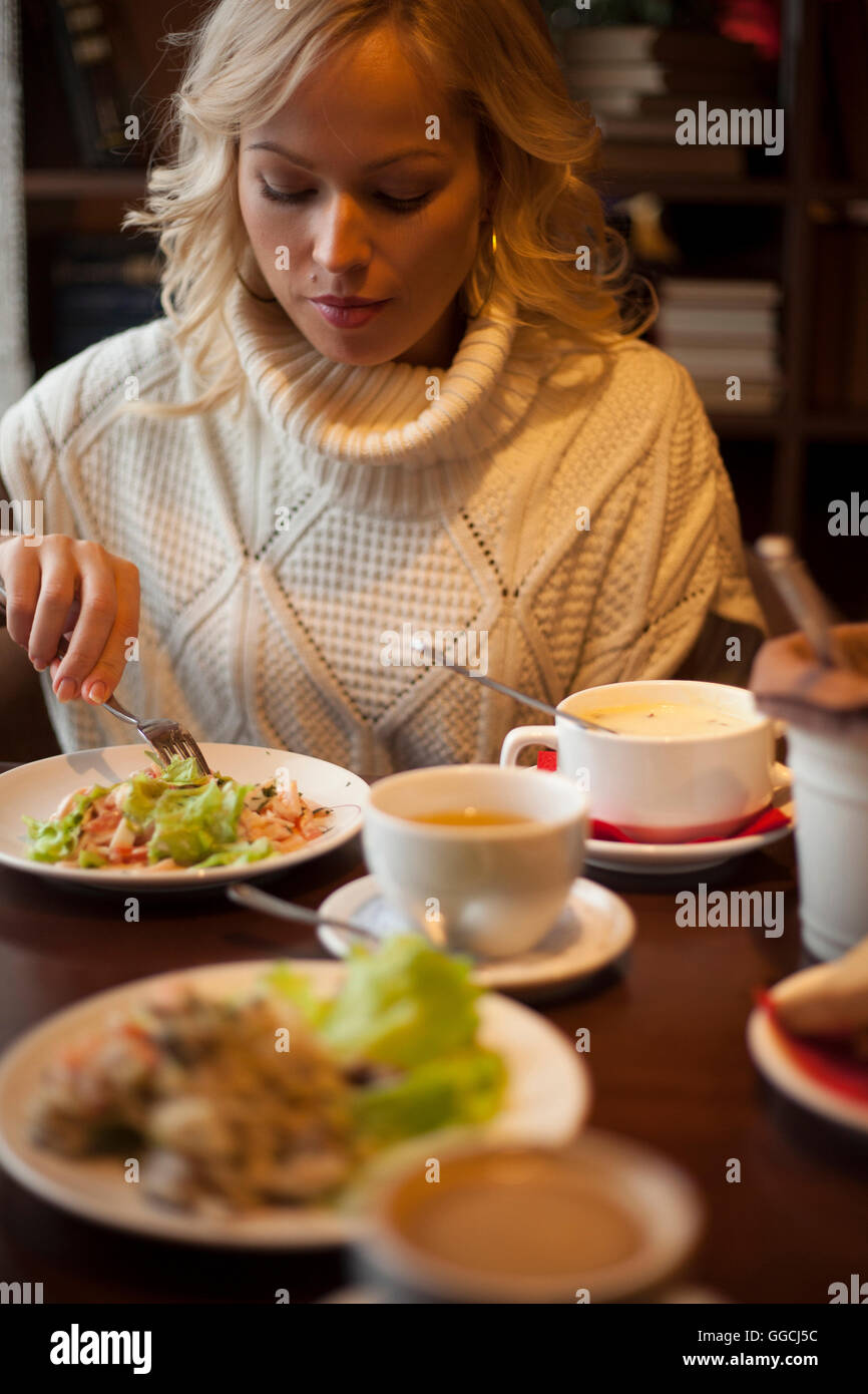 Caucasian woman eating at table Stock Photo - Alamy