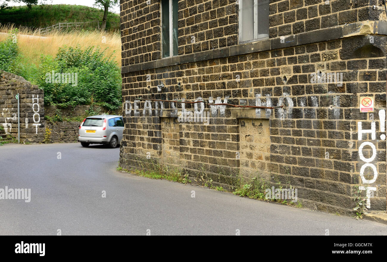 Hoot! Warning signs painted on a building at a blind bend on a narrow ...