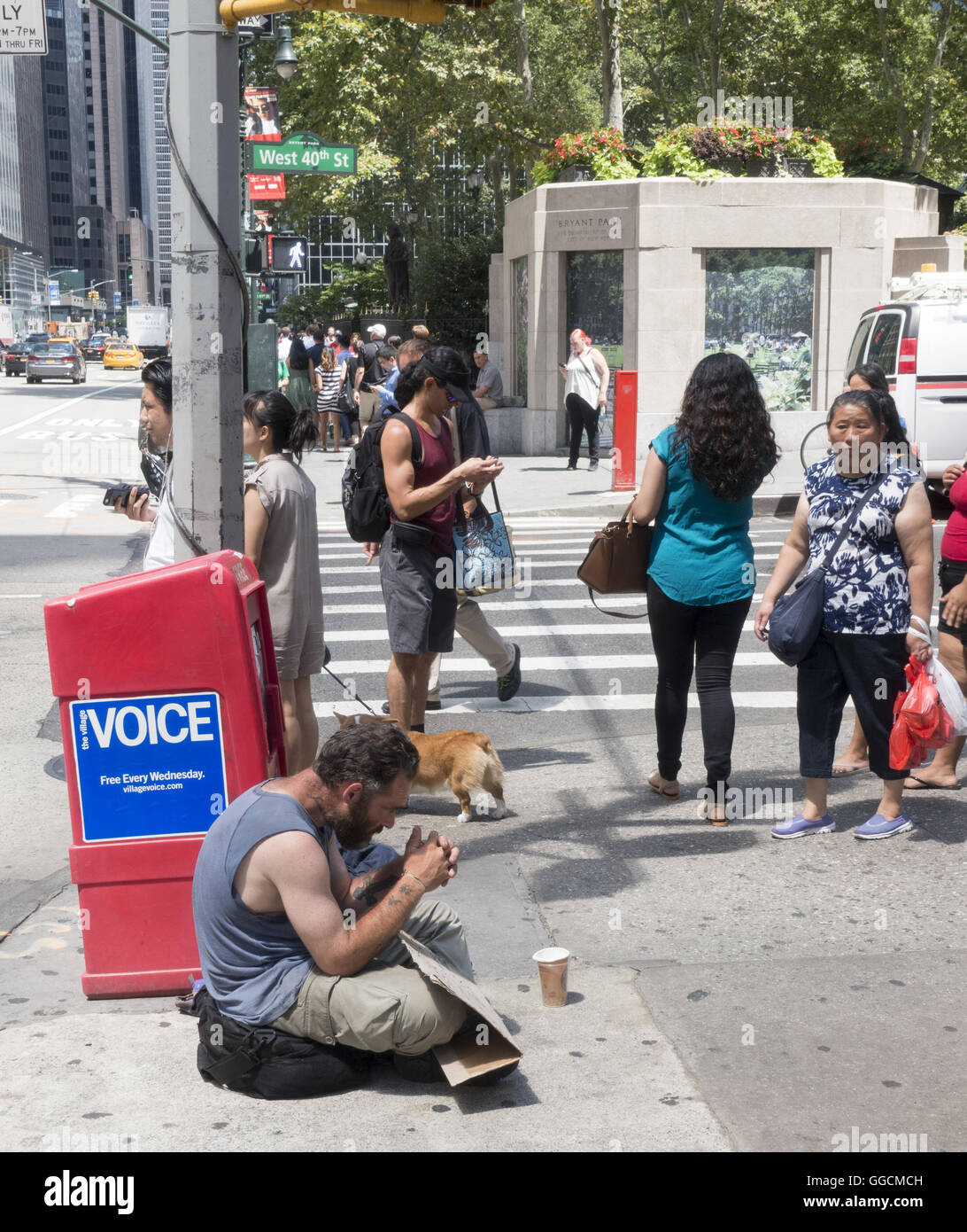 Homeless man sits on the sidewalk looking for help along 6th Ave. at ...