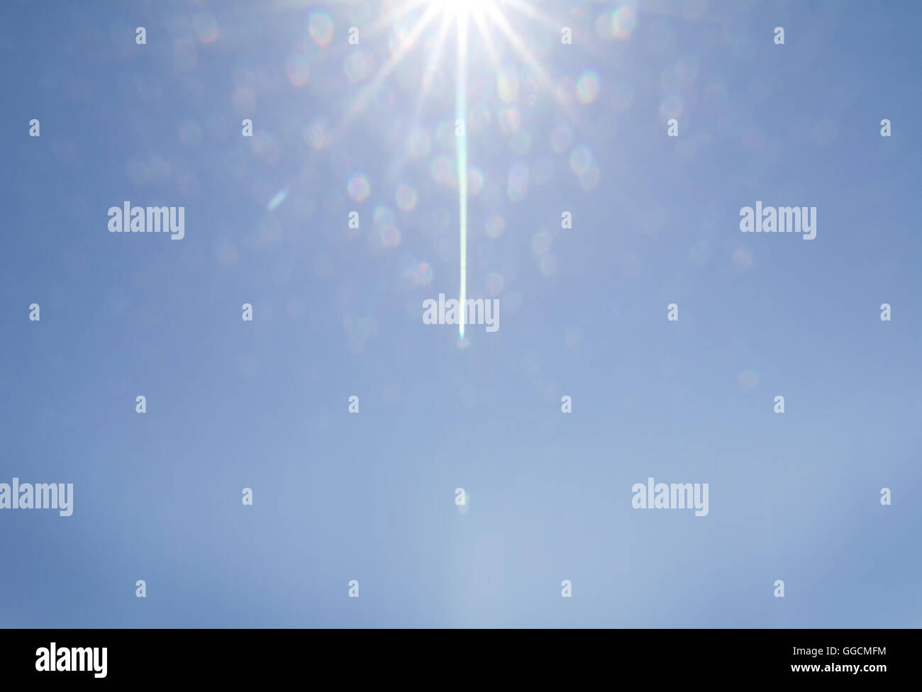 Sun shining from blue sky light effects background Stock Photo - Alamy