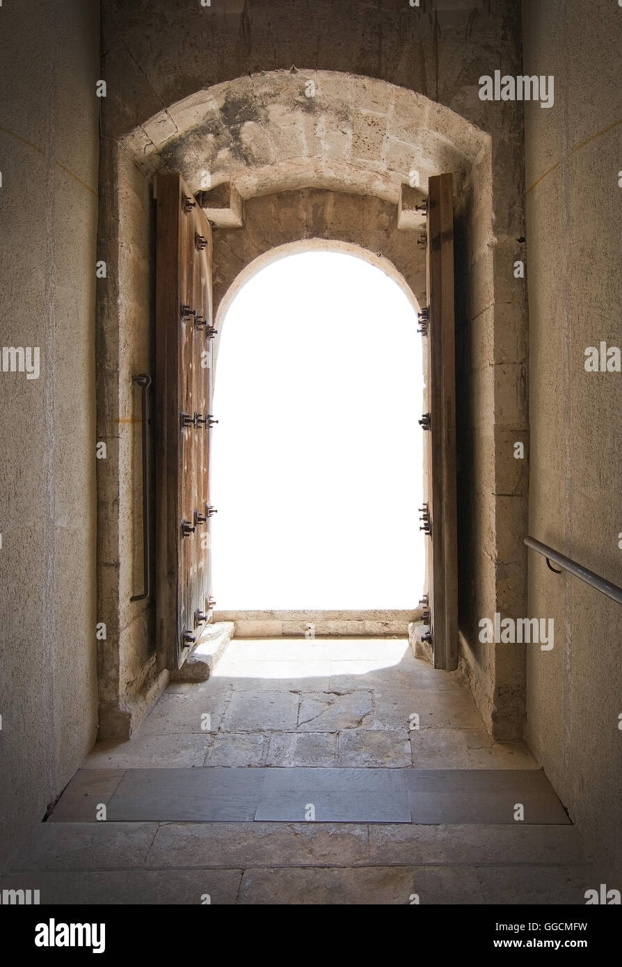 Old interior stone building with vault leading out to white copy space ...