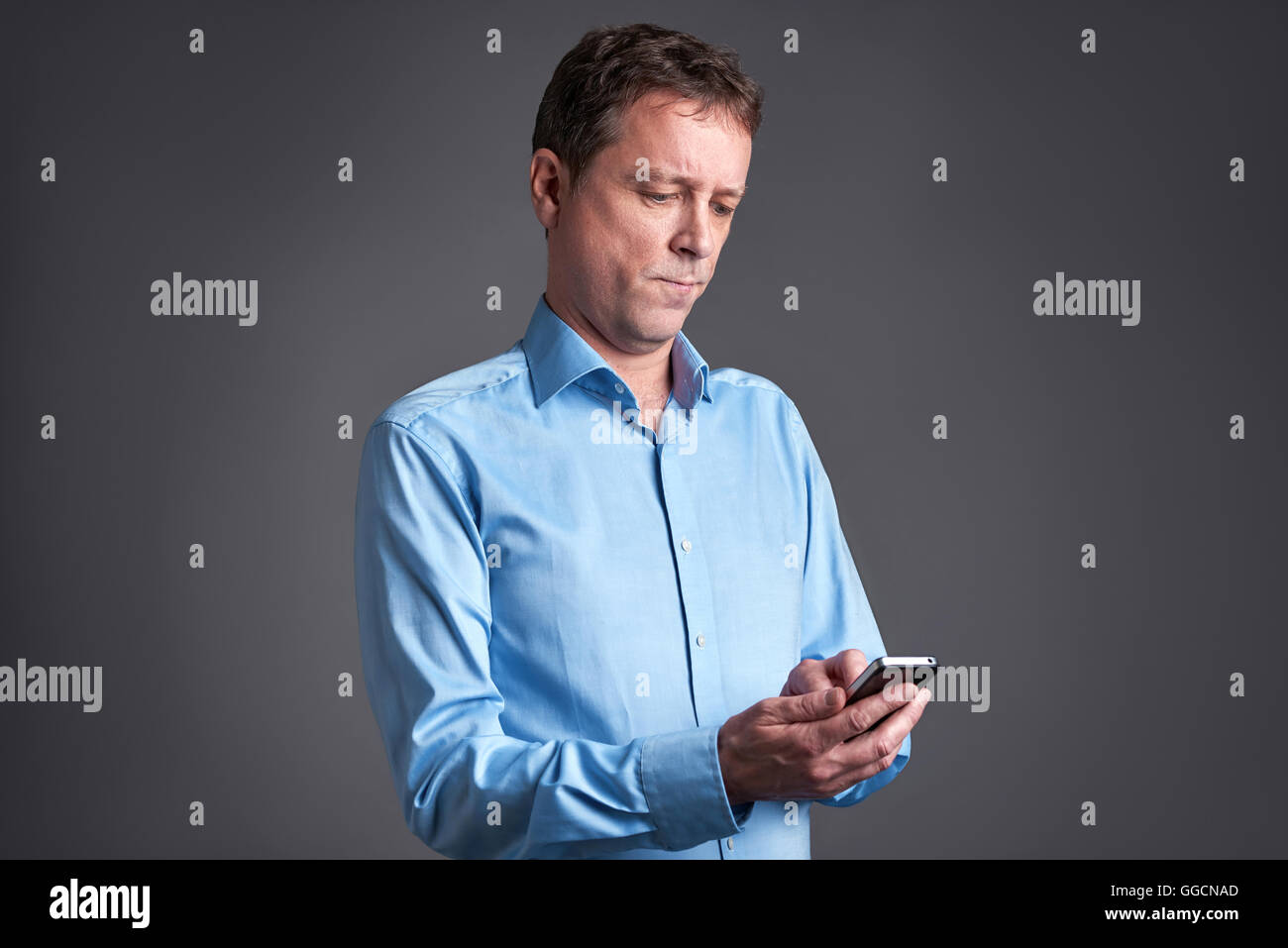A middle age man standing and using a smartphone Stock Photo - Alamy