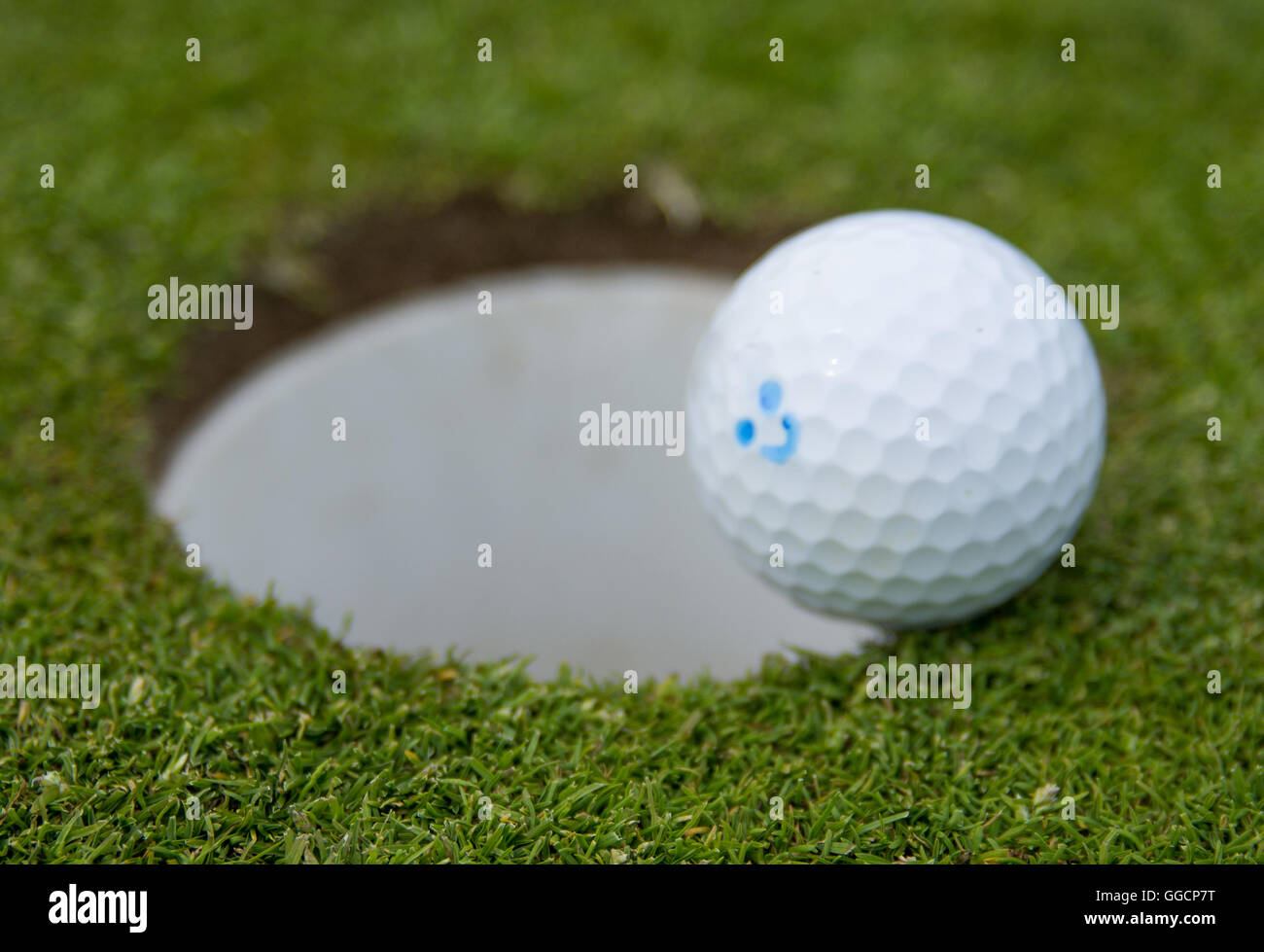 A blank golf ball dropping into the hole Stock Photo - Alamy