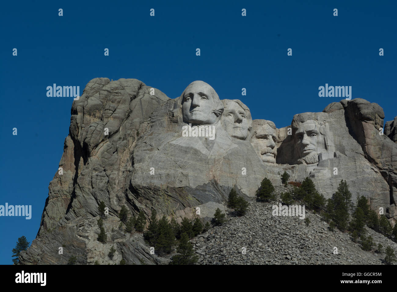 The four Presidents carved into Mount Rushmore stare out against a blue ...
