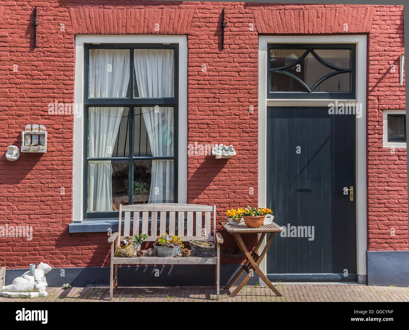Red house with a bench in front of it Stock Photo - Alamy