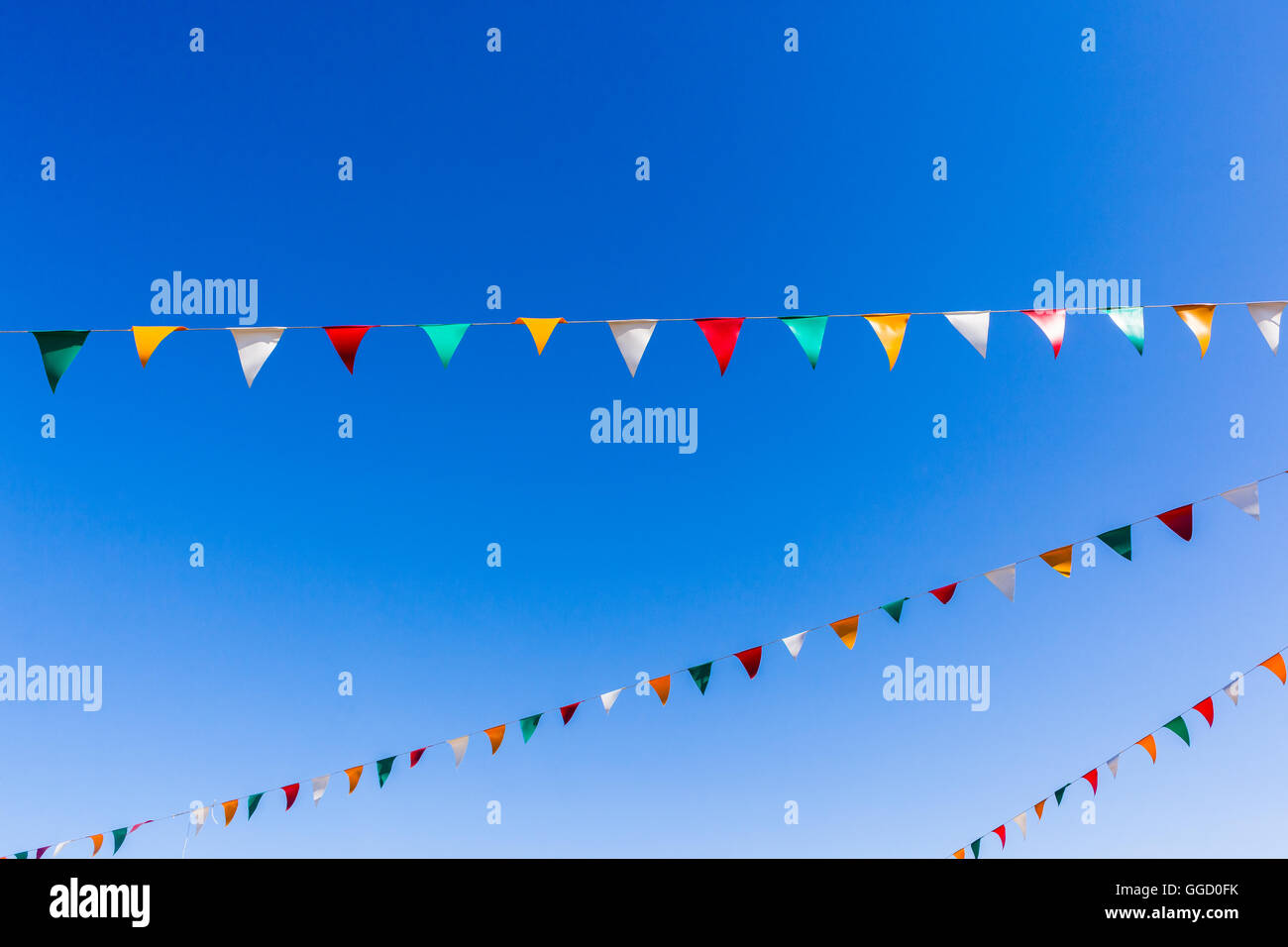 Flags individual colors suspended in blue sky Stock Photo - Alamy