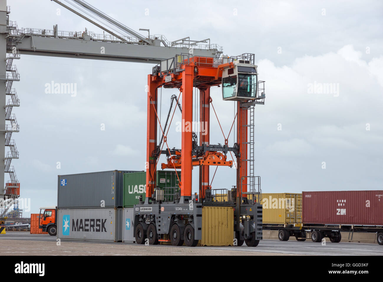 Straddle carrier about to pick up a container Stock Photo - Alamy
