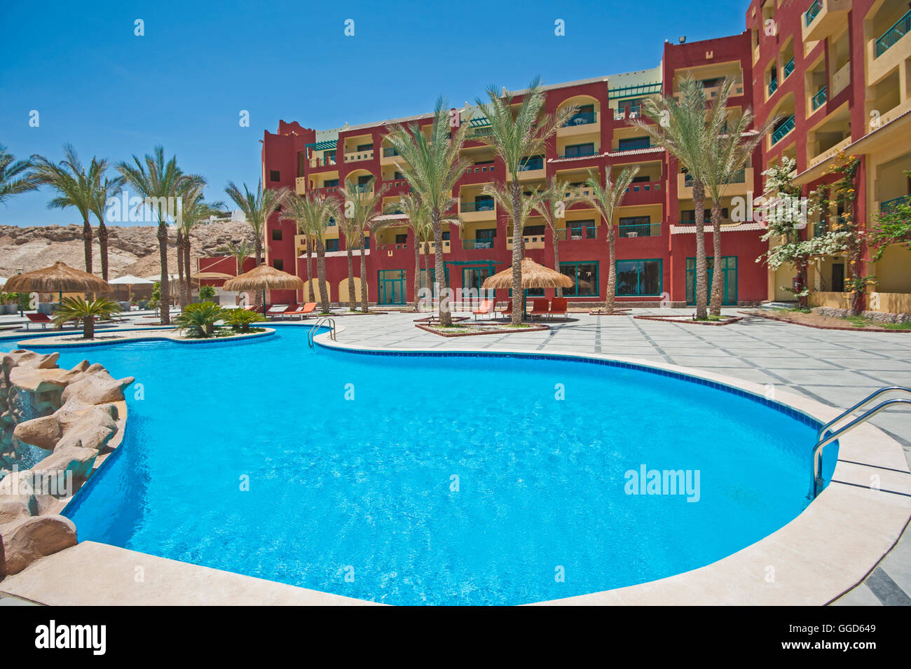 View over a swimming pool in luxury tropical hotel resort with date ...