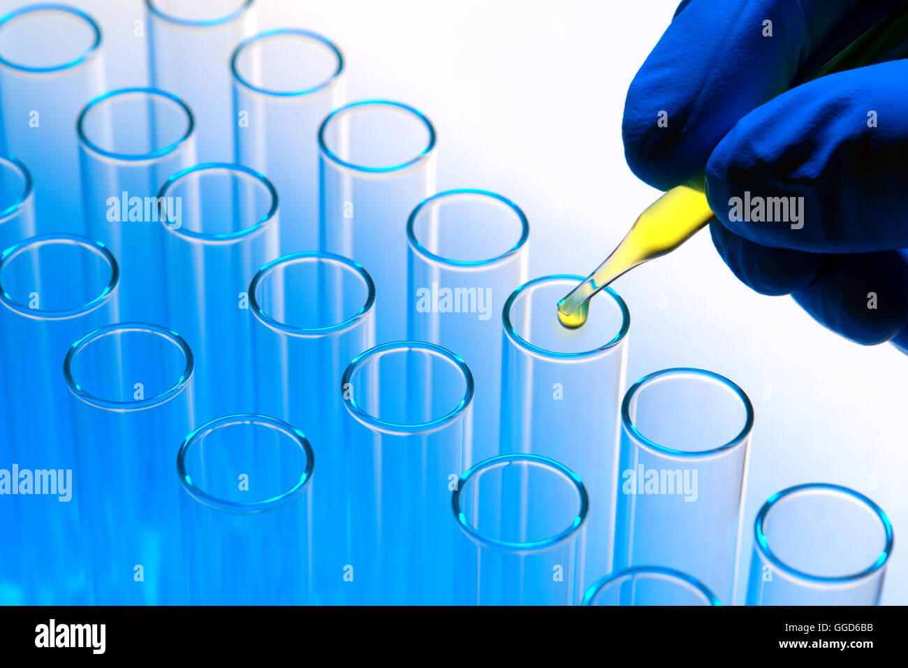 Scientist hand holding laboratory glass pipette with drop of liquid ...