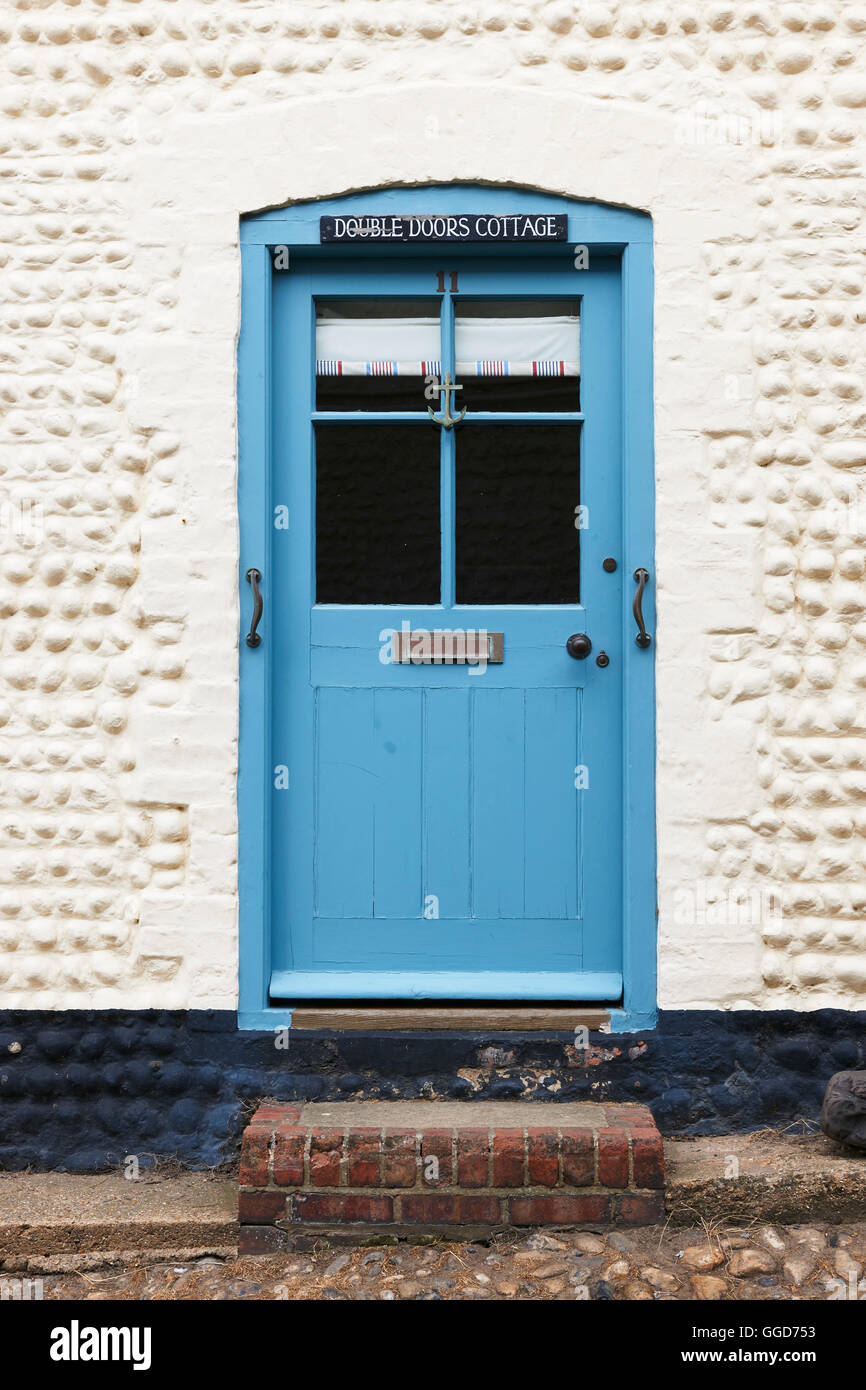 Blue door set into a cobbled wall with sign above Stock Photo - Alamy
