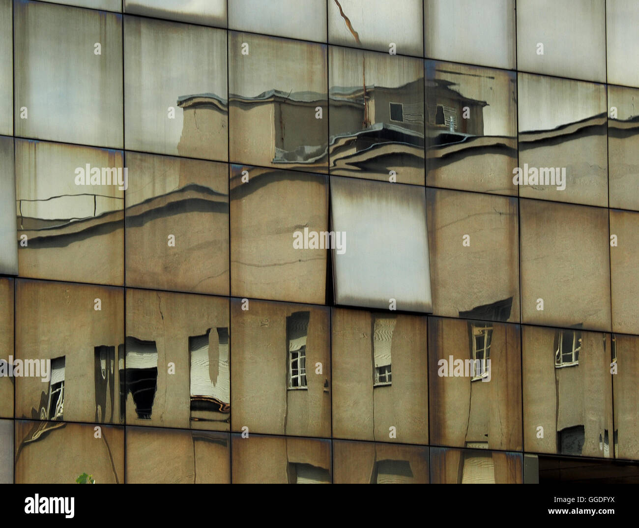 abstract reflections of nearby buildings distorted in flat glass window ...