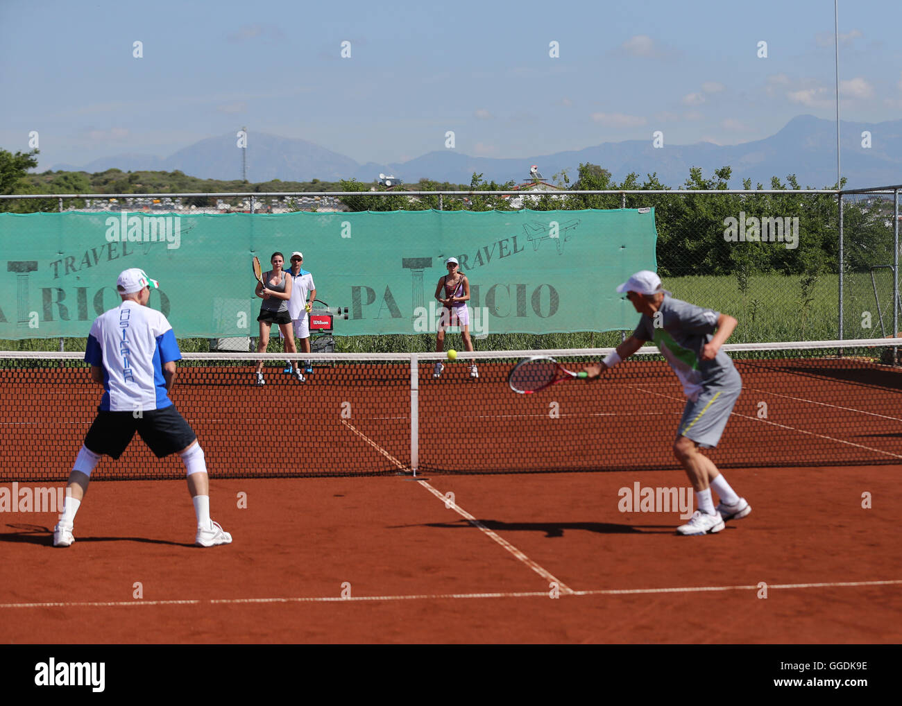 Tennis coach giving lesson to players on a tennis court Stock Photo - Alamy
