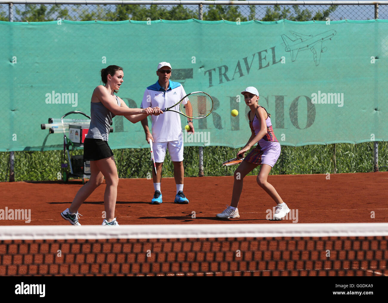 Tennis coach giving lesson to players on a tennis court Stock Photo - Alamy
