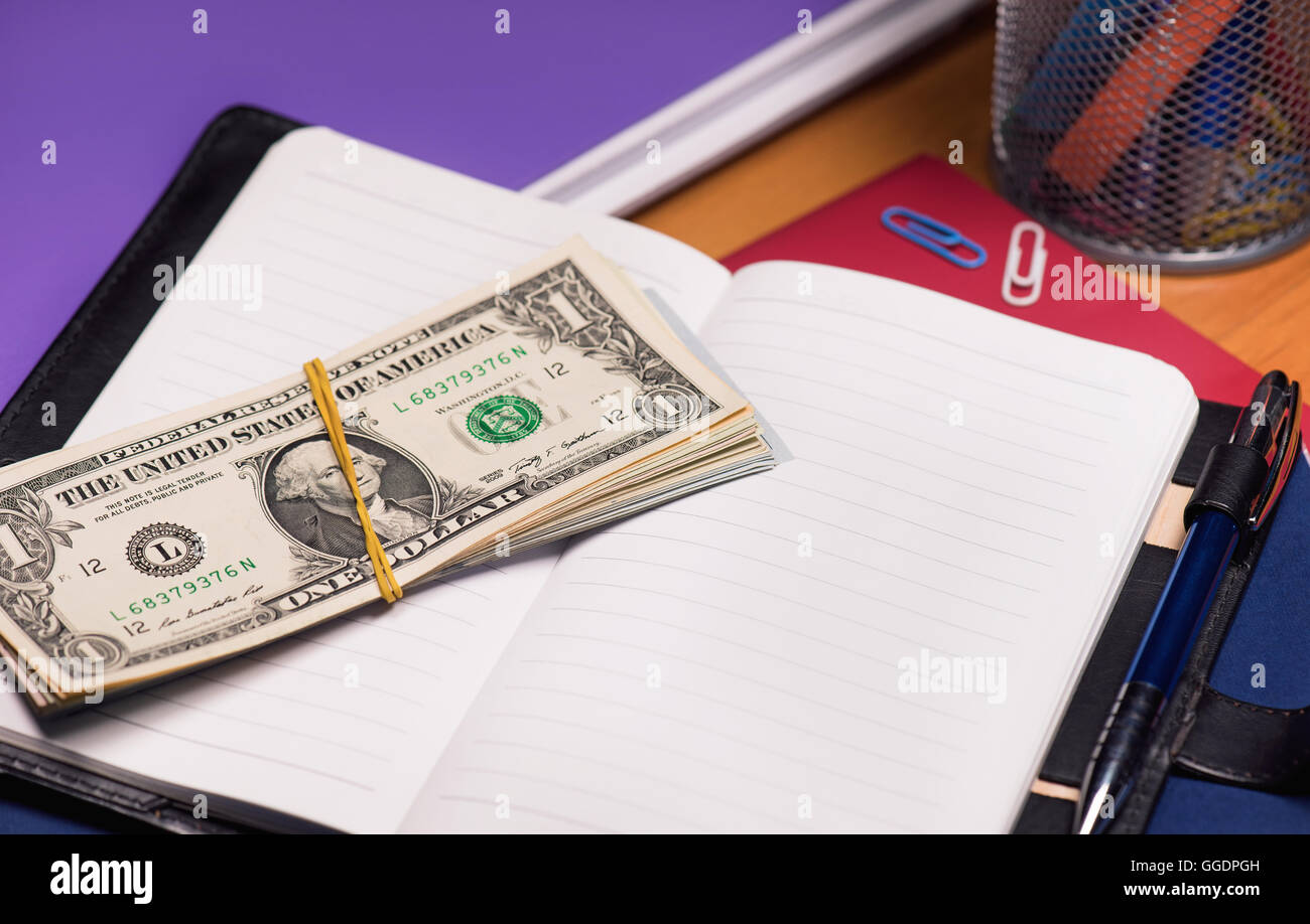 Notepad with dollar banknotes Stock Photo - Alamy