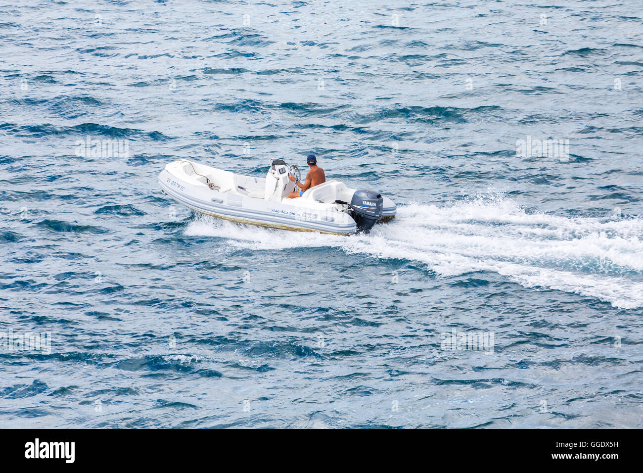 Man in Small White Boat speeding across water Stock Photo - Alamy