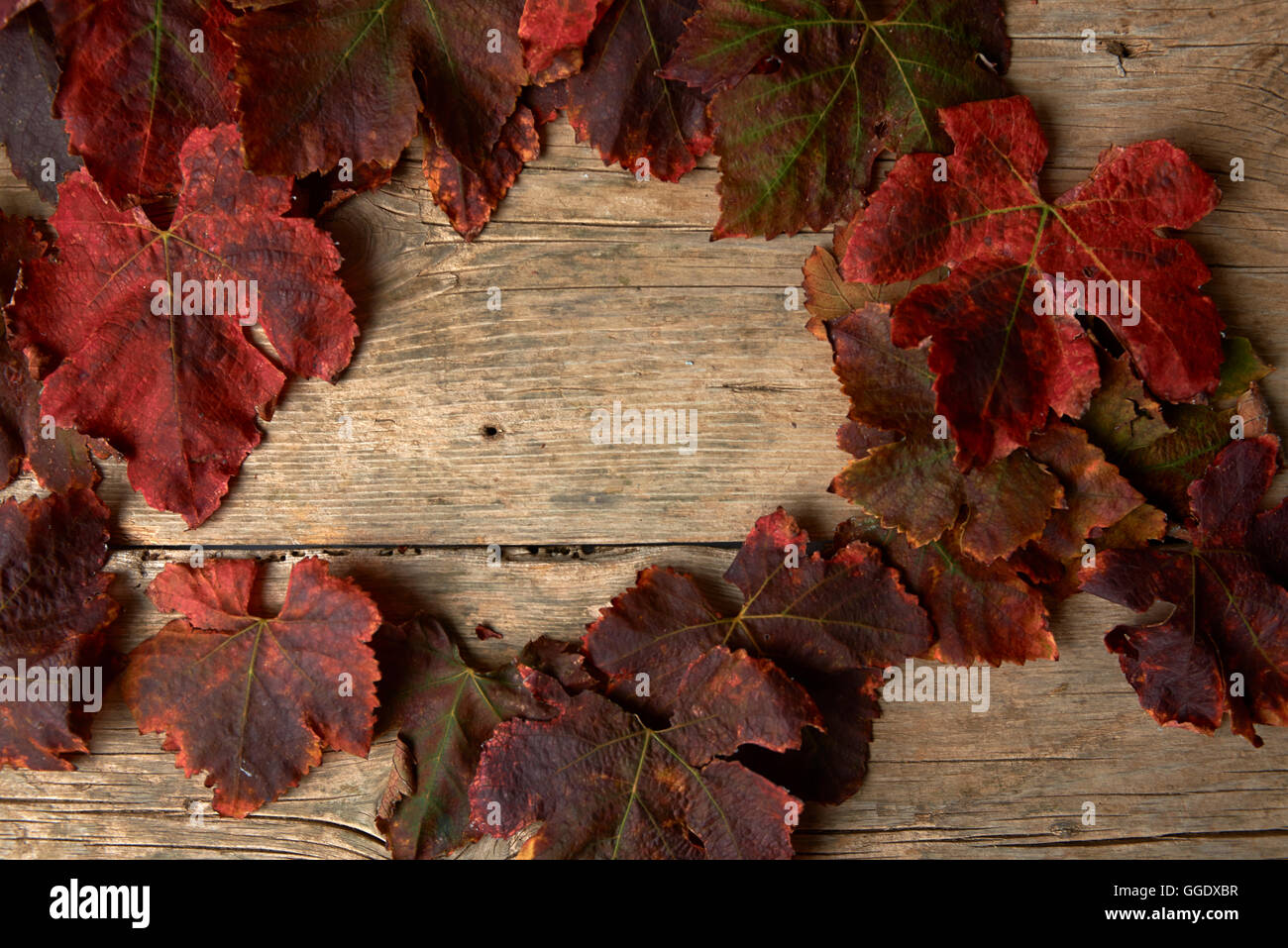 Autumn red grape leaves over wooden background Stock Photo - Alamy