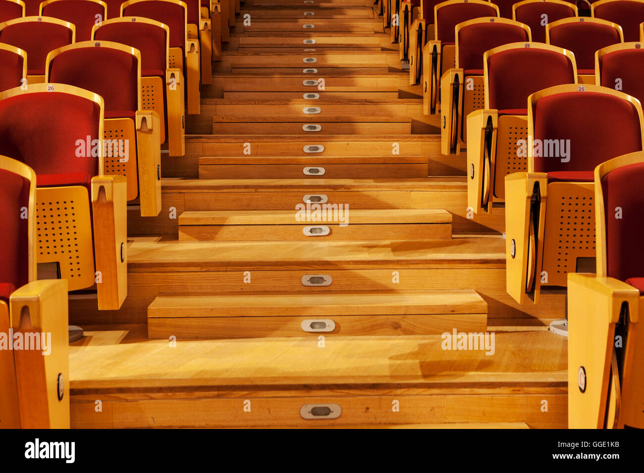 rows of red theater seats with wooden arm Stock Photo - Alamy