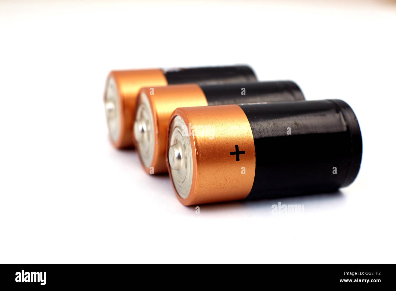 gold batteries in rows with silver tops close up Stock Photo - Alamy