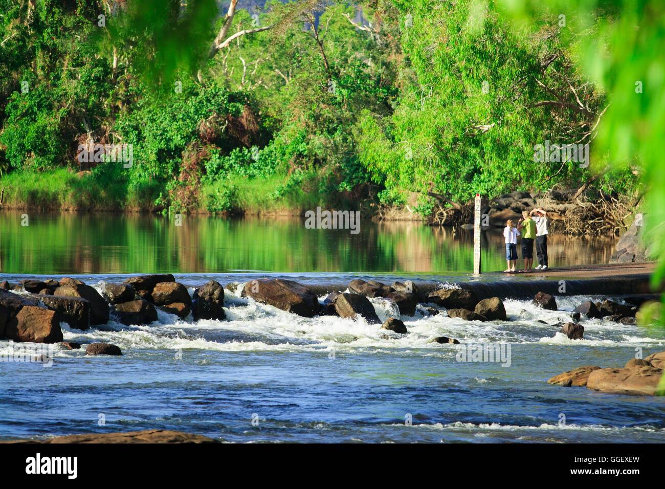 A group of people stand dangerously close to the crocodile infested ...
