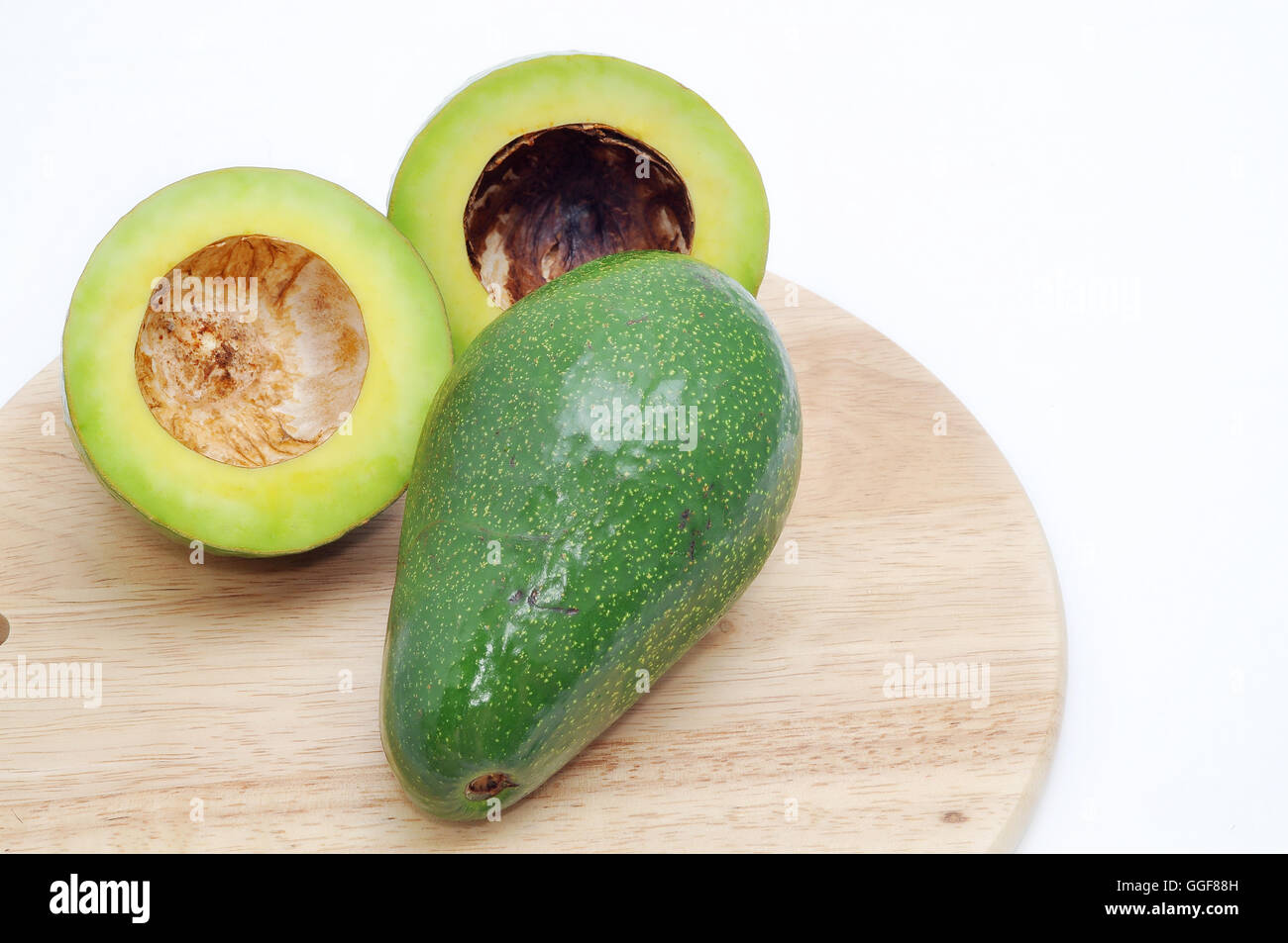 Avocado on the cutting board in a white background Stock Photo - Alamy