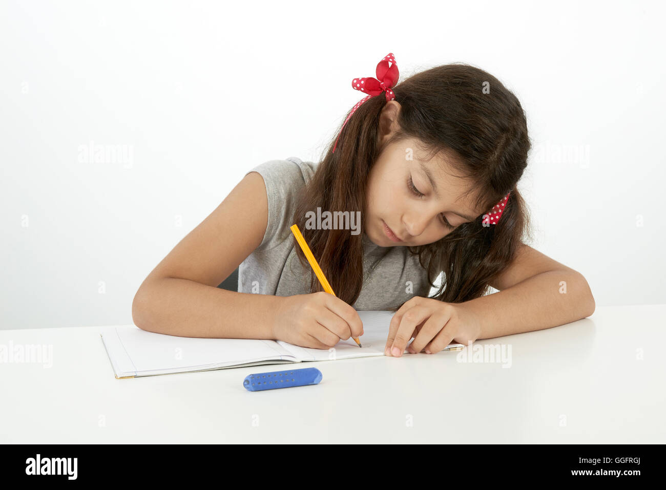 education and school concept. Little girl writing with pencil Stock ...