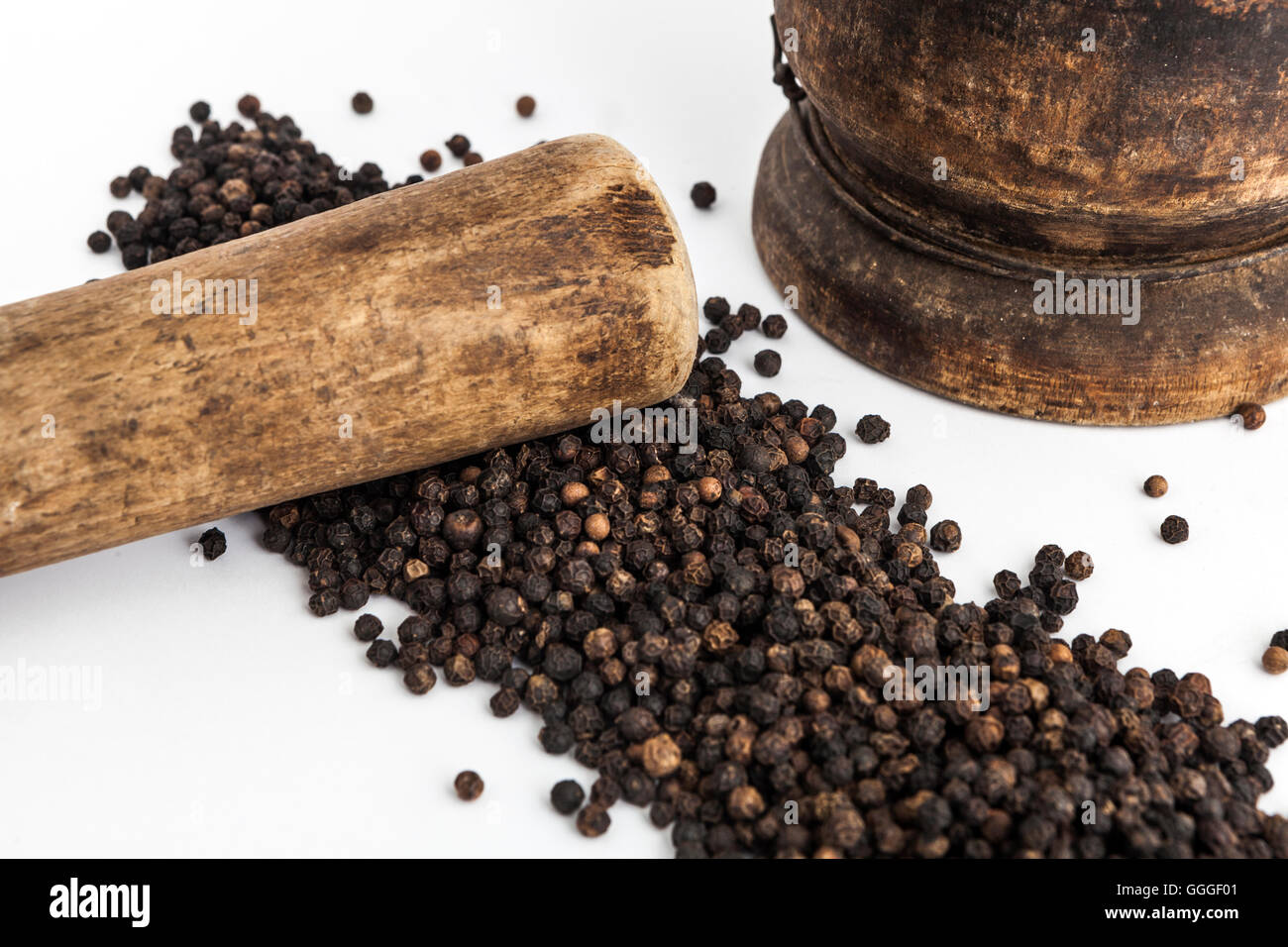 Mortar and pestle with pepper seeds closeup in studio on white ...