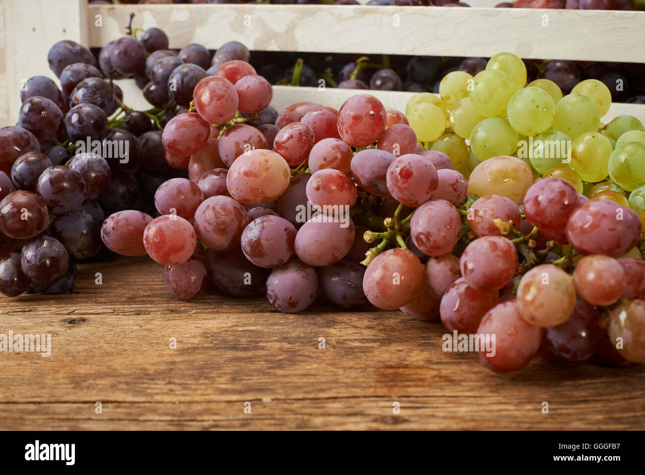 bunch of fresh grapes on a wooden kitchen bench Stock Photo - Alamy
