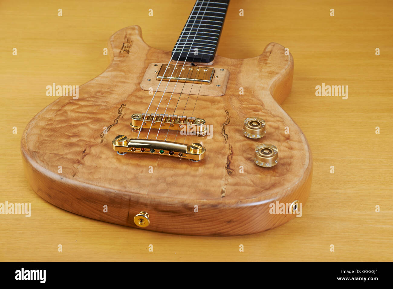 Guitar, wooden natural color with golden accessories Stock Photo - Alamy