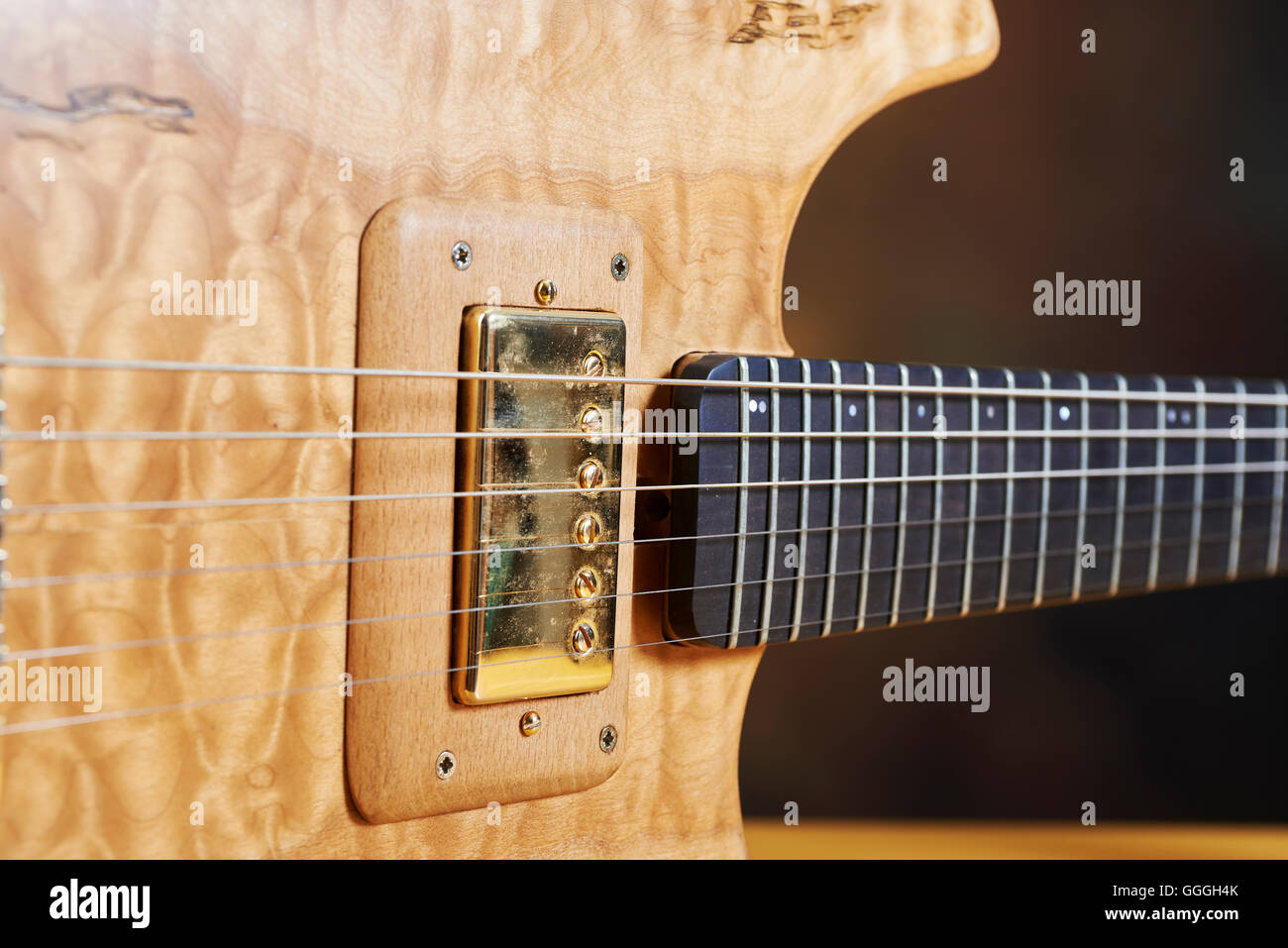 Guitar, wooden natural color with golden accessories Stock Photo - Alamy