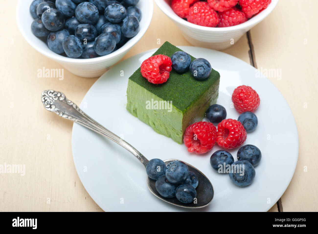 green tea matcha mousse cake with raspberries and blueberries on top ...