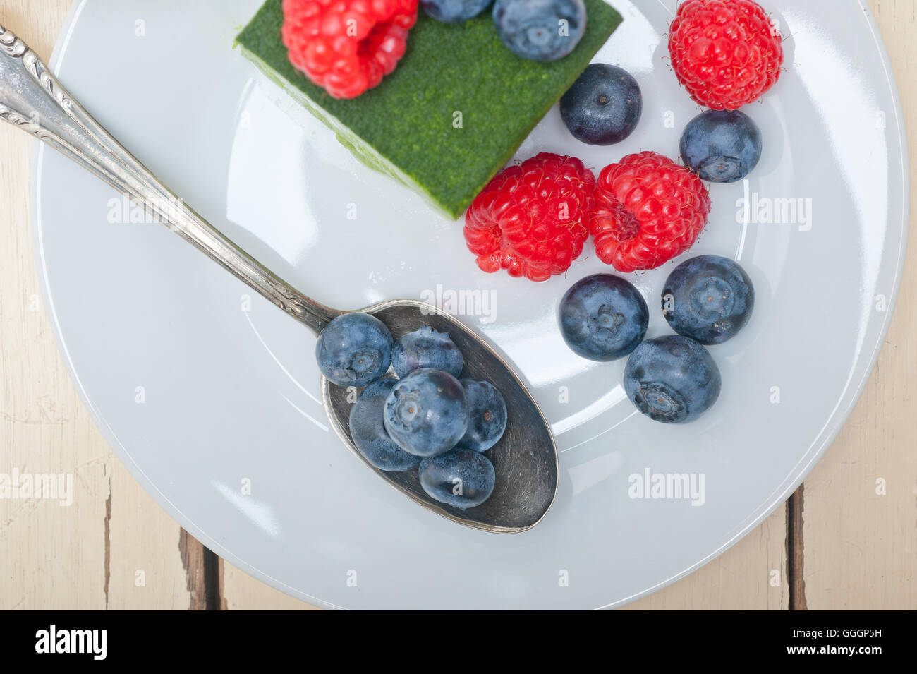 green tea matcha mousse cake with raspberries and blueberries on top ...
