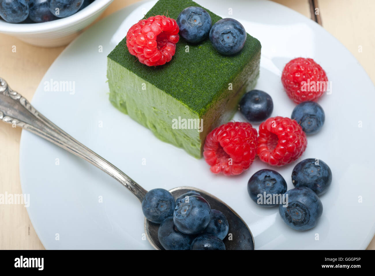 green tea matcha mousse cake with raspberries and blueberries on top ...