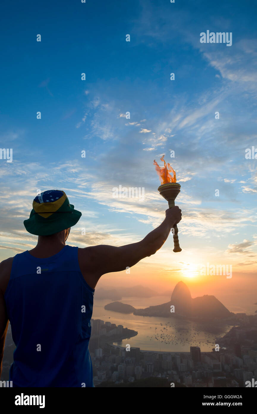 Torchbearer athlete wearing hat holding sport torch standing in ...