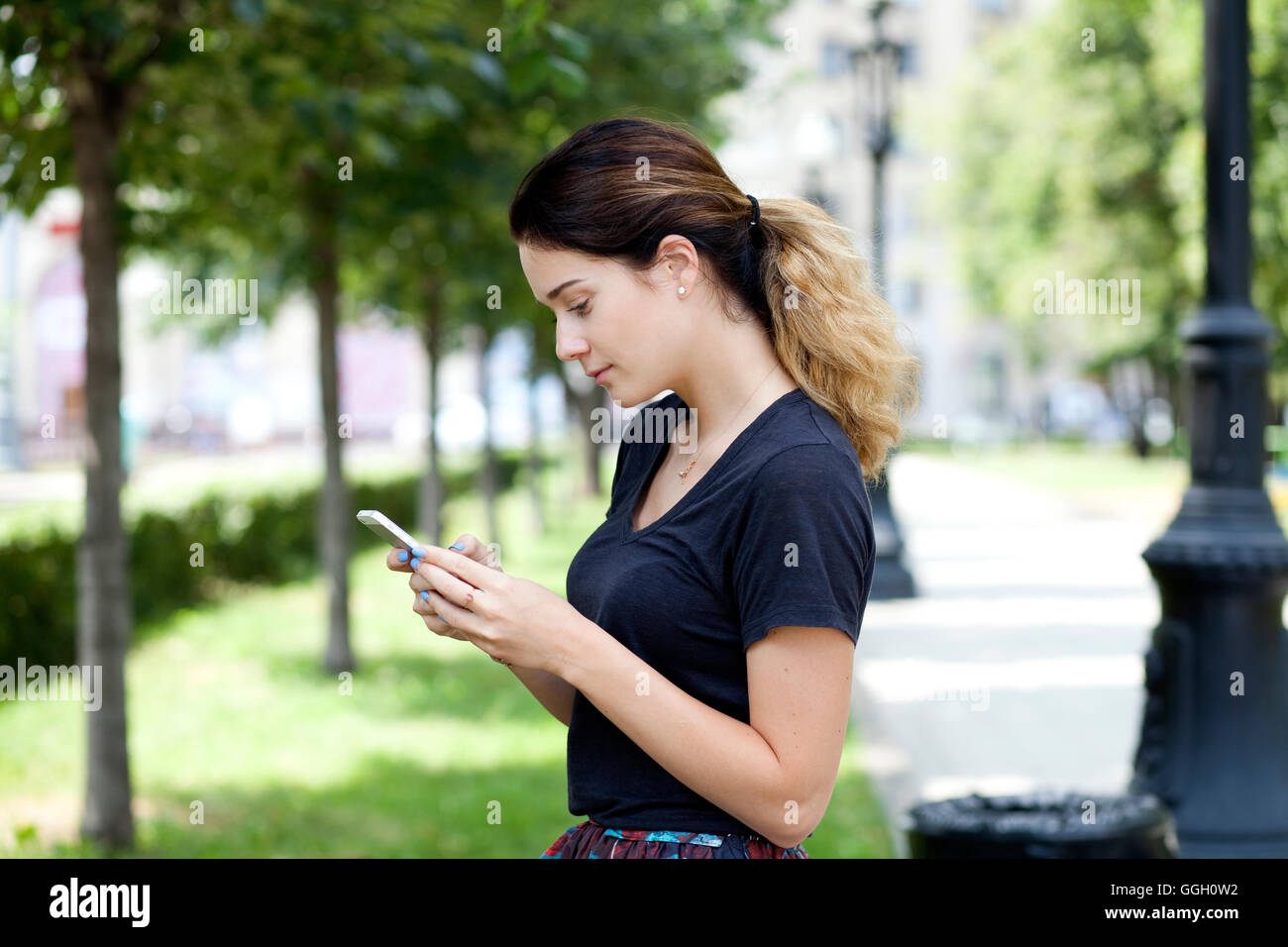 Young woman reading a message on the phone Stock Photo - Alamy