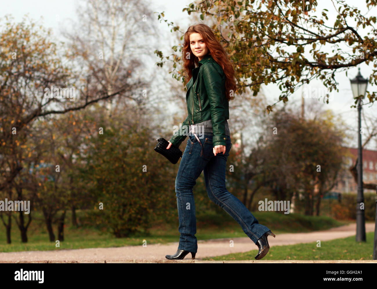 Full length, walking woman in autumn park Stock Photo - Alamy