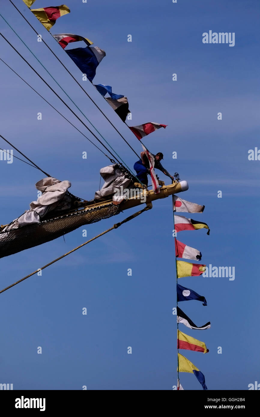 Men hanging different national flags in forestay over a bowsprit of a ...