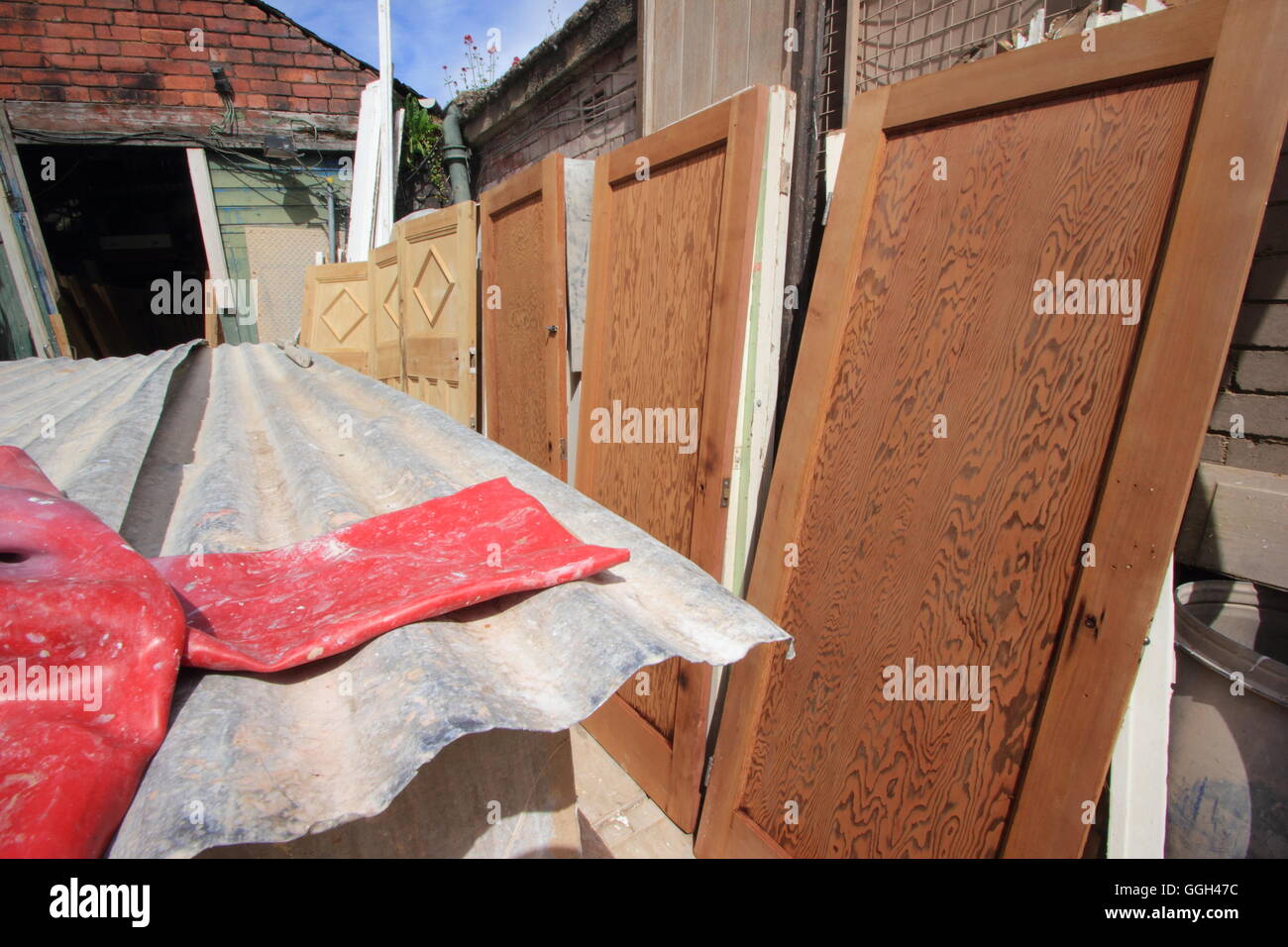Freshly stripped vintage pine doors dry in the sun by a caustic ...