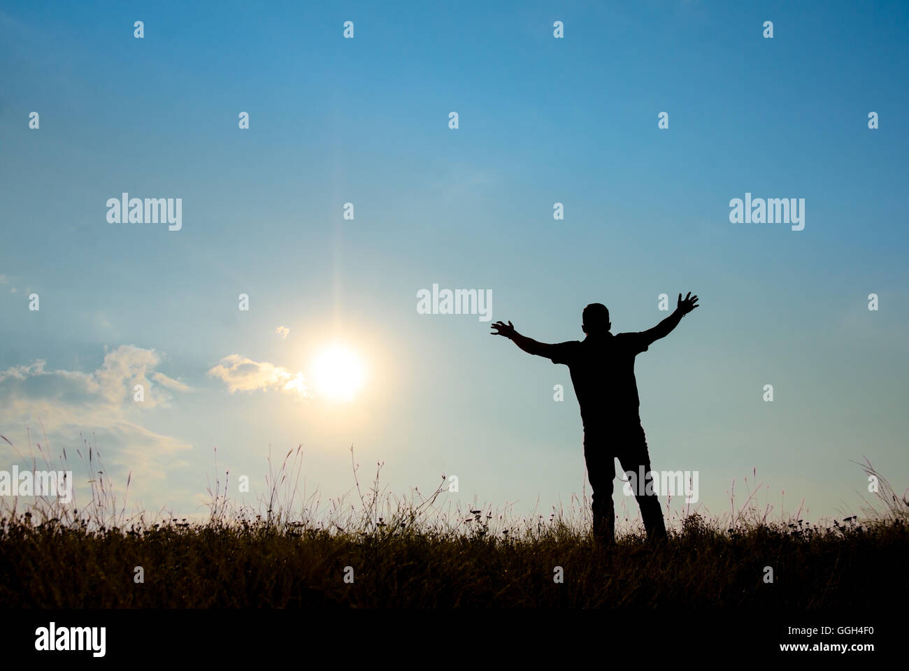 Silhouette of man worship with hands raised to the sky in nature ...