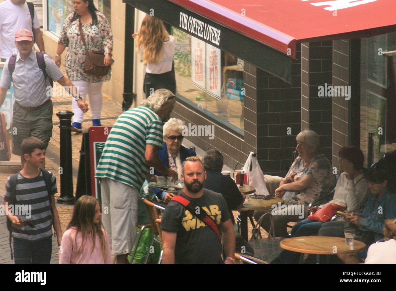 crowd walking through a town with Costa coffee shop in background Stock ...