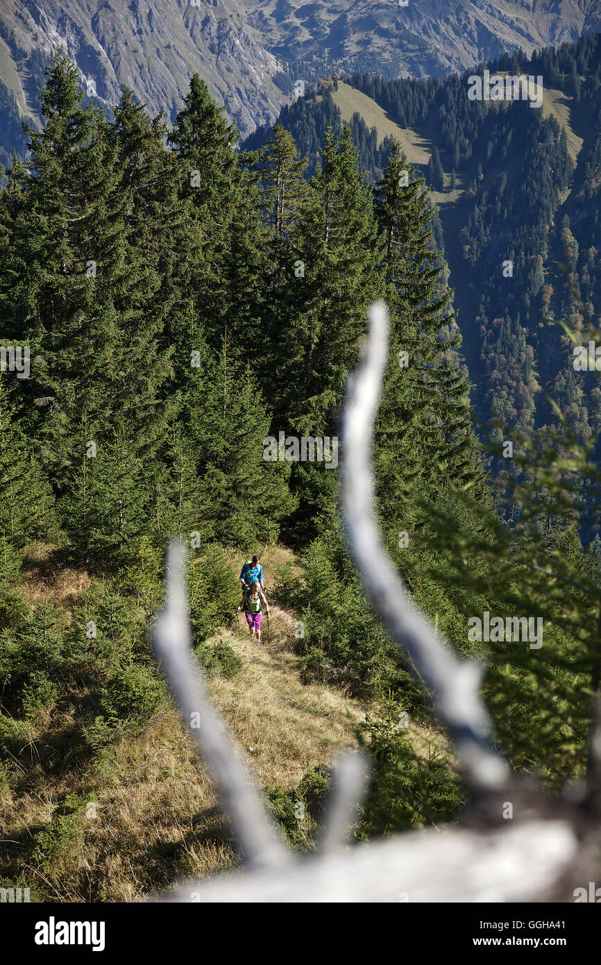 A man and a woman hiking on a trail in the mountains, Oberstdorf ...
