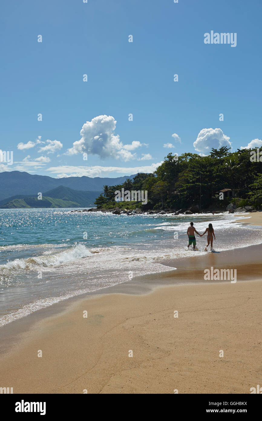 Couple walking hand in hand on the beach, Praia do Curral, western side ...