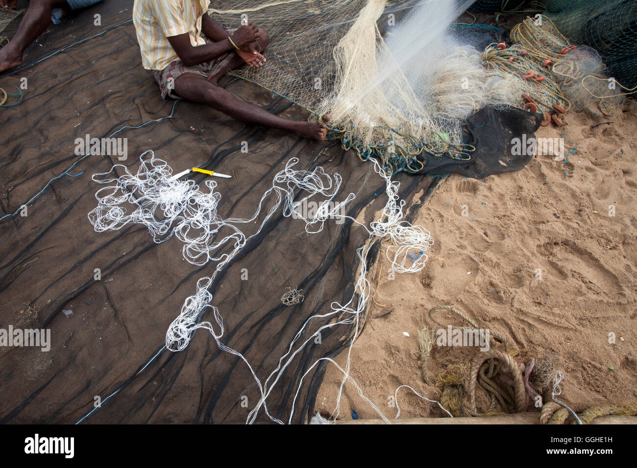 A fisherman mending fishing net.close view Stock Photo - Alamy