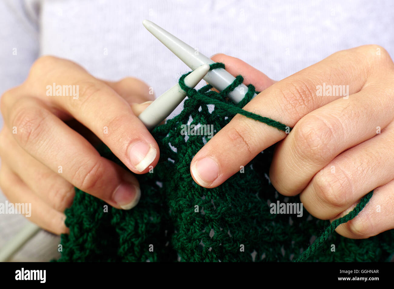 Woman knitting clothes with green wool Stock Photo - Alamy