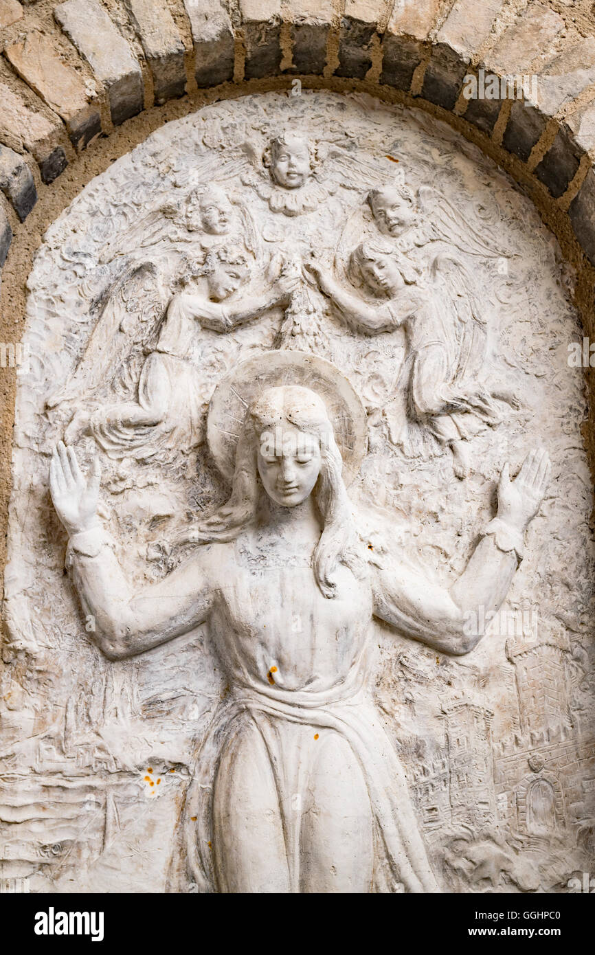Bas relief surrounded by brick wall representing the Virgin Mary ...