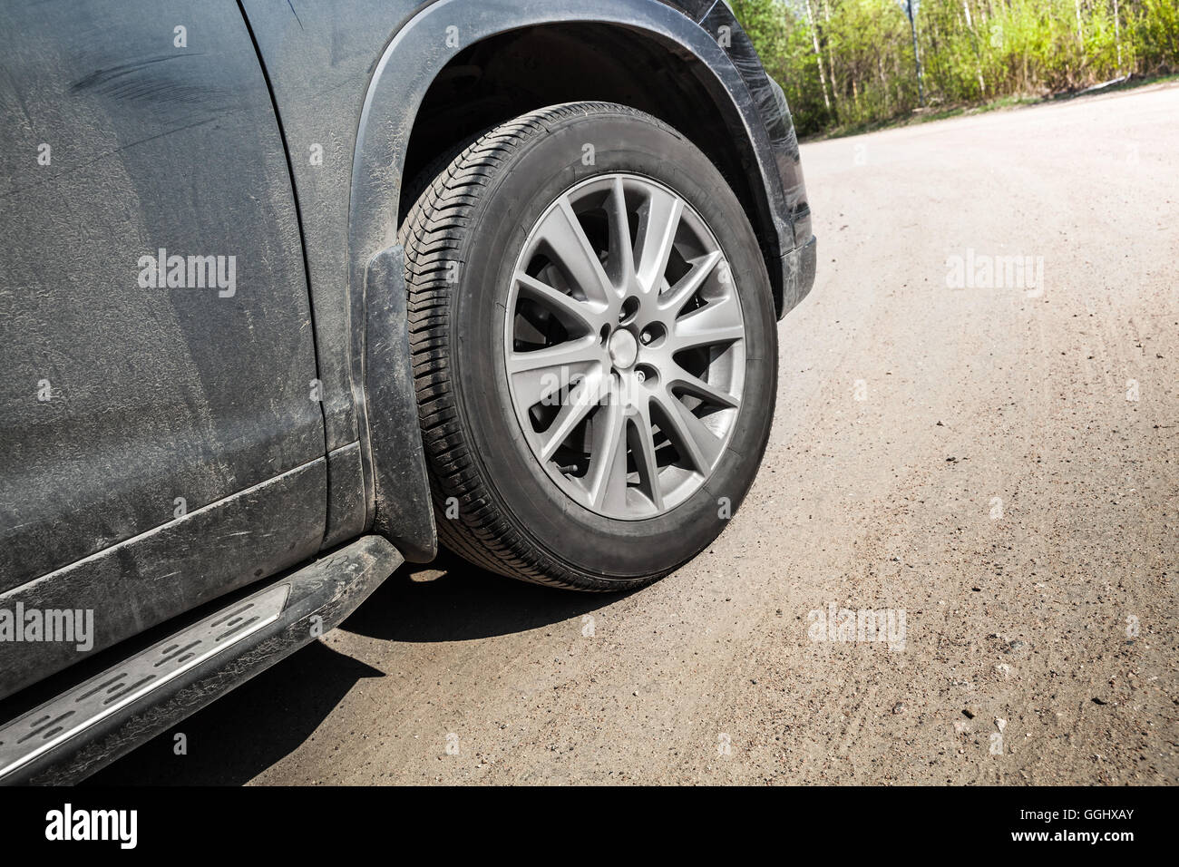 Unidentifiable SUV car fragment. Wheel with light alloy disc on country ...