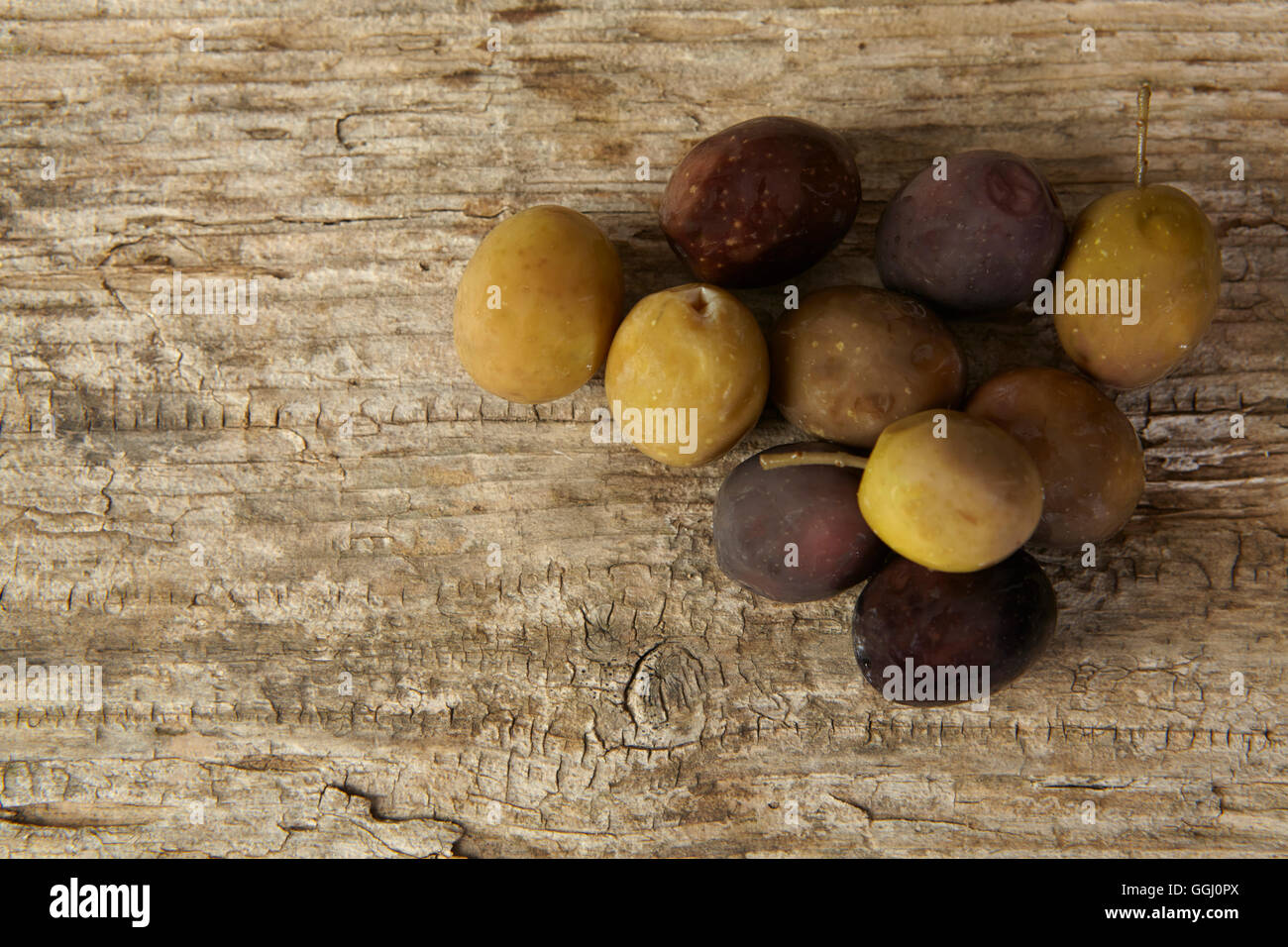 group of olives on a wooden table Stock Photo - Alamy