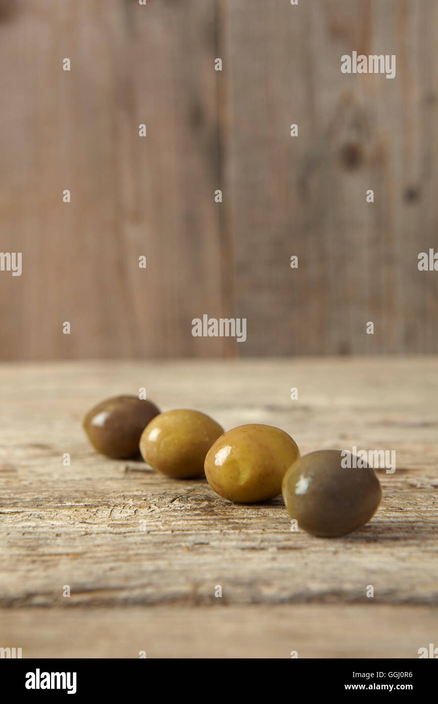 group of olives on a wooden table Stock Photo - Alamy