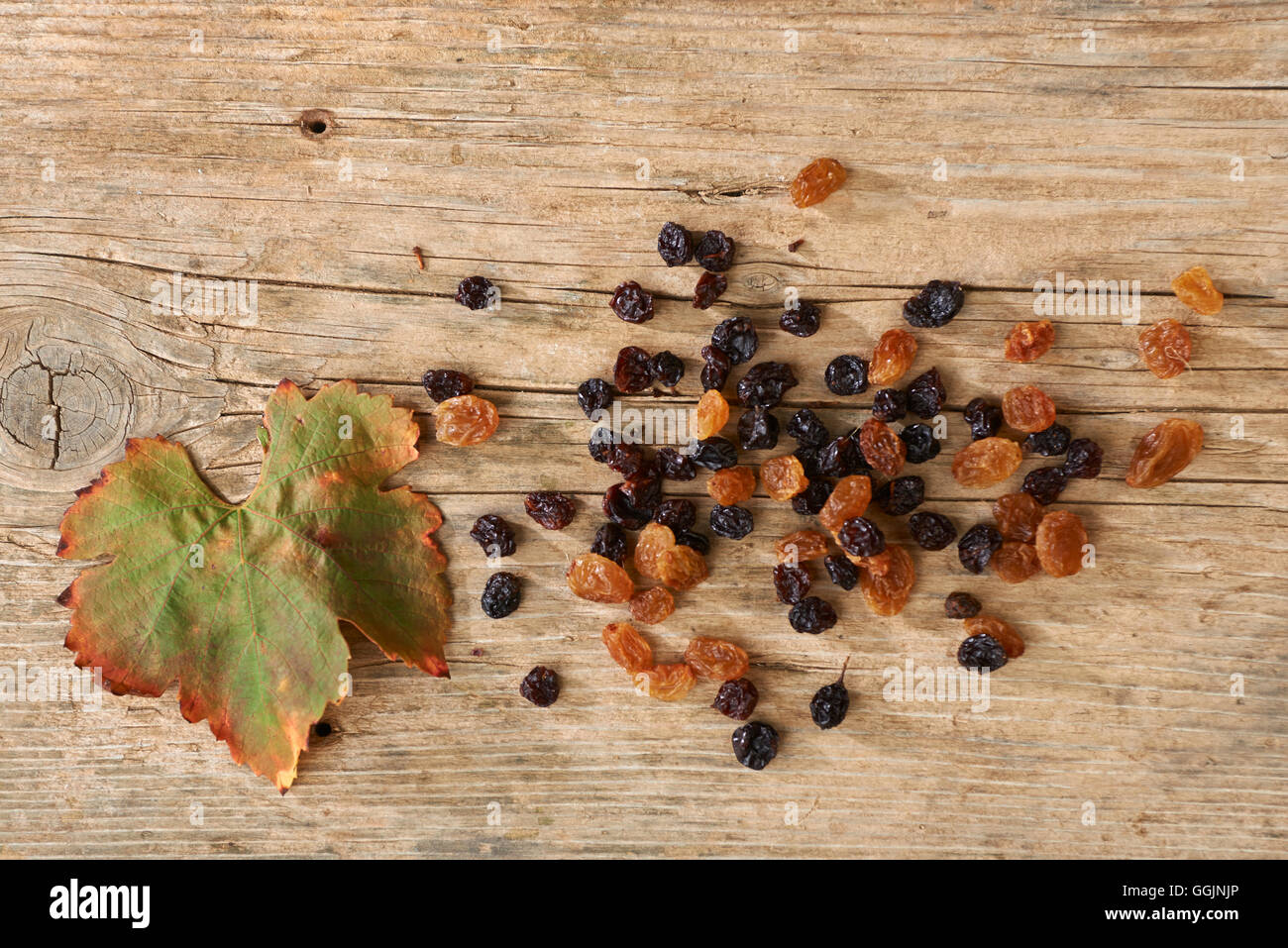 Golden and black raisins over wooden table Stock Photo - Alamy