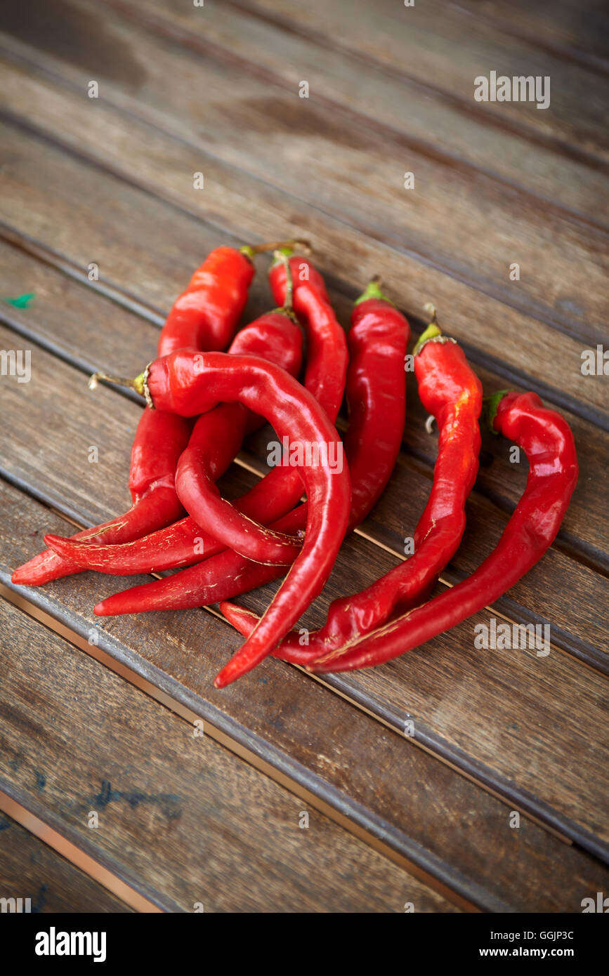 red hot chili peppers on wooden table Stock Photo - Alamy