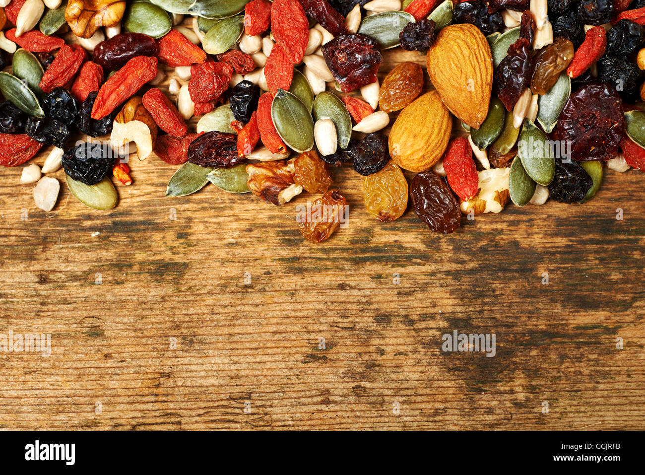 mix nuts seeds and dry fruits, on a wooden table Stock Photo - Alamy